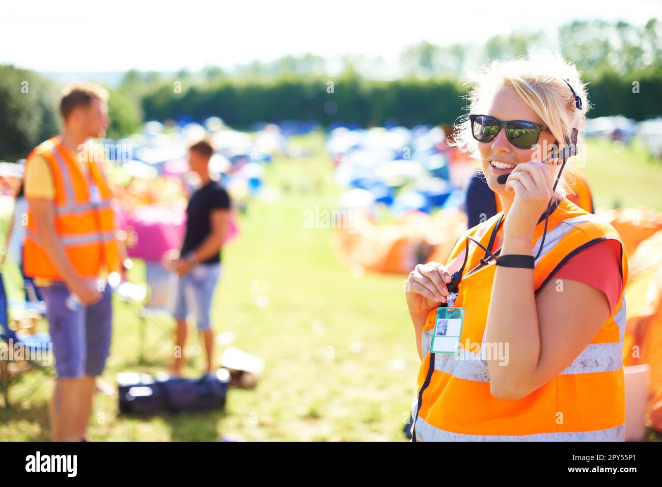 Festival security, communication and a woman outdoor on a grass field ...
