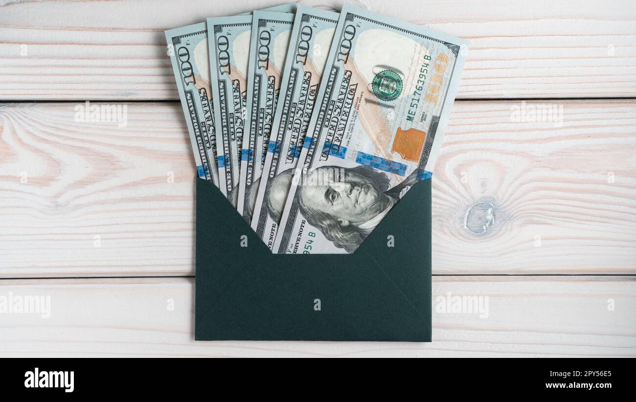 Flat lay of green envelope with one hundred dollars banknotes bill ...