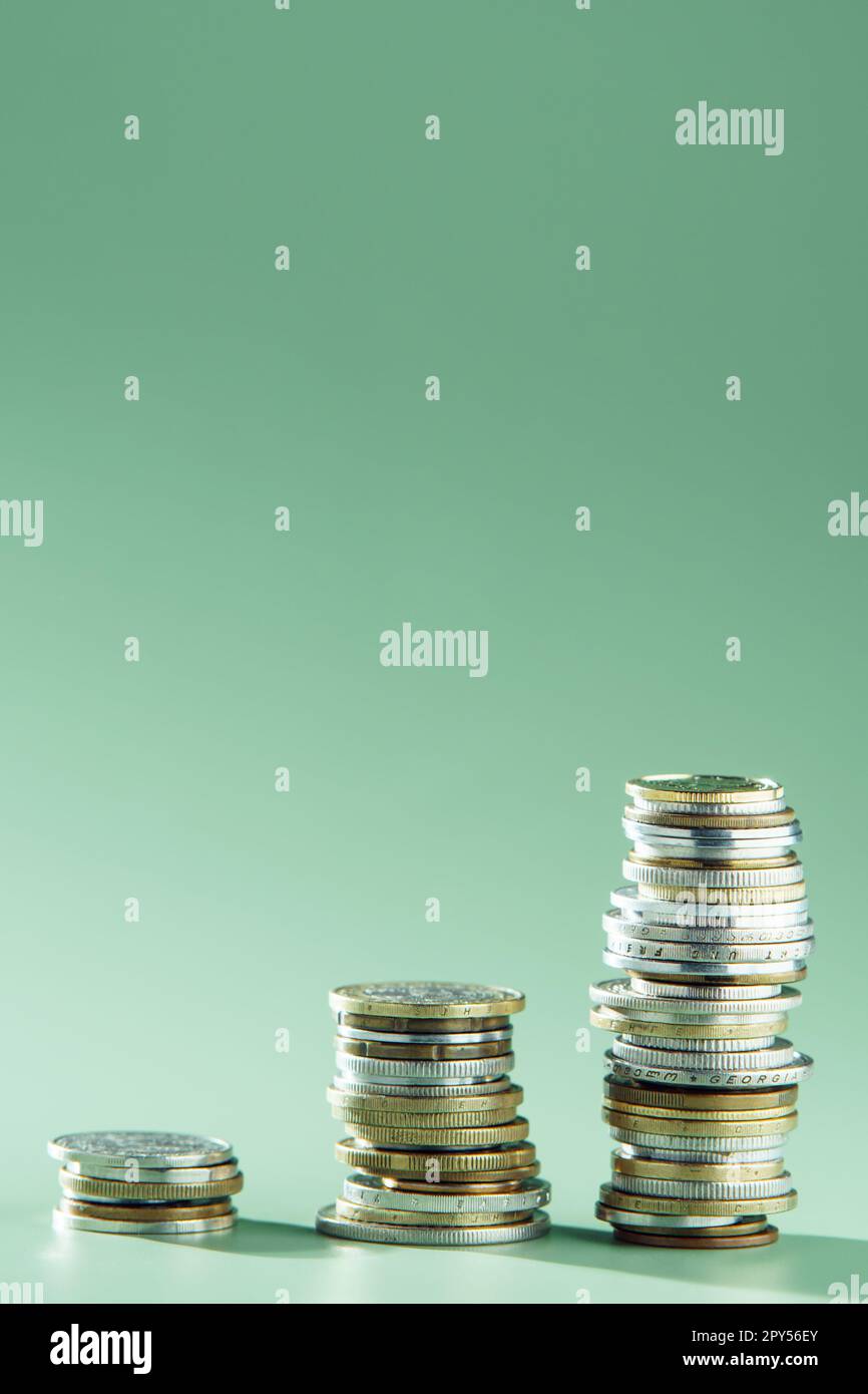 Side view of three stacks of different coins arranged in growing graph ...