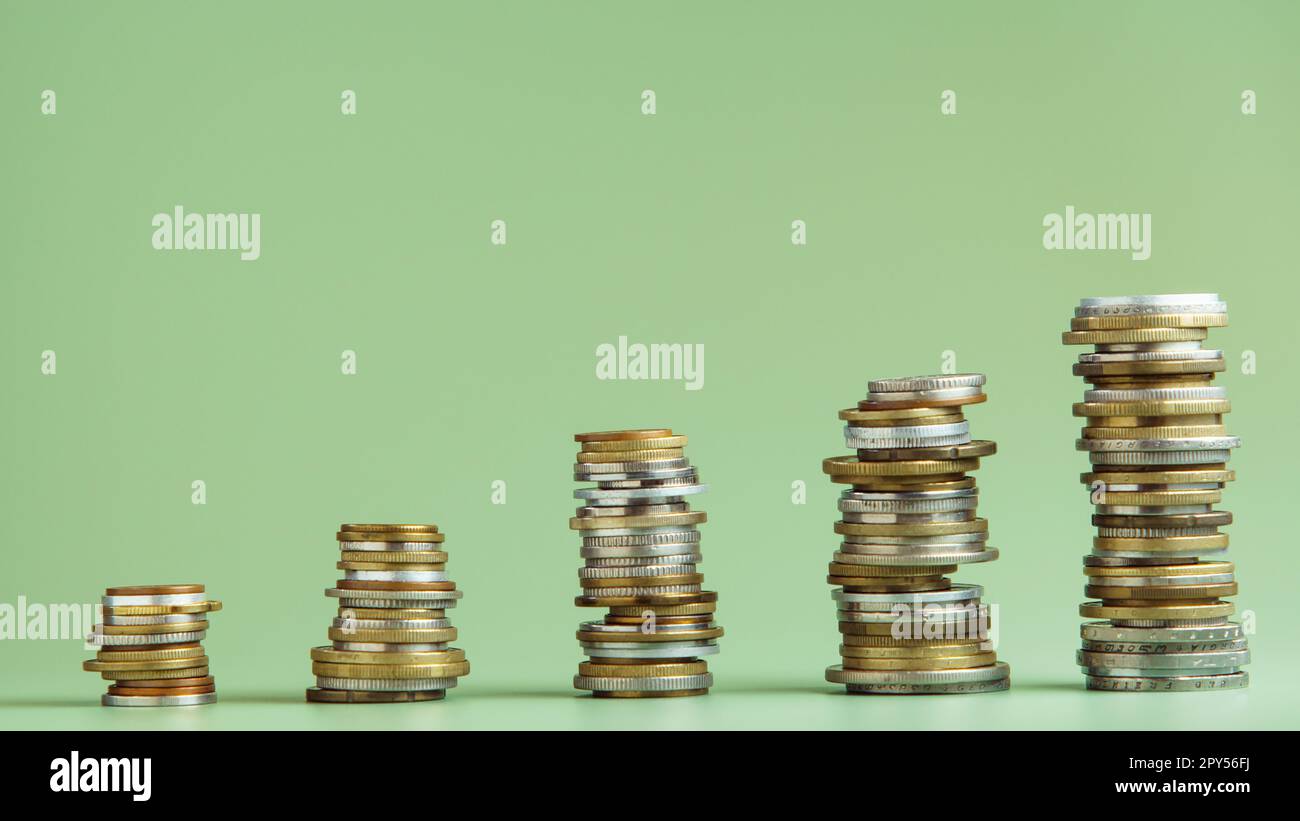 Side view of five stacks towers of different coins arranged in growing ...