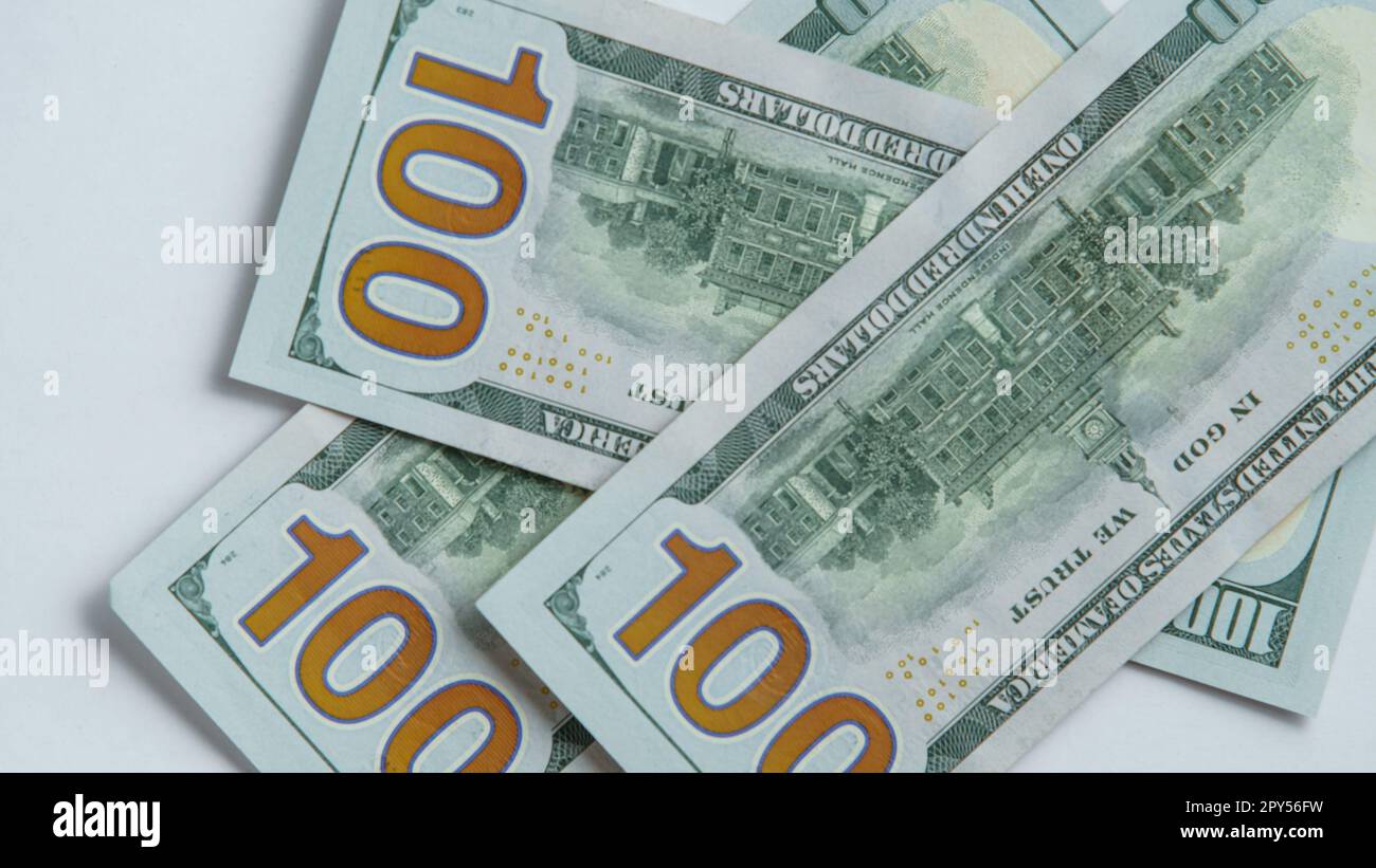 Flat lay of several one hundred 100 dollars banknotes bills on white ...