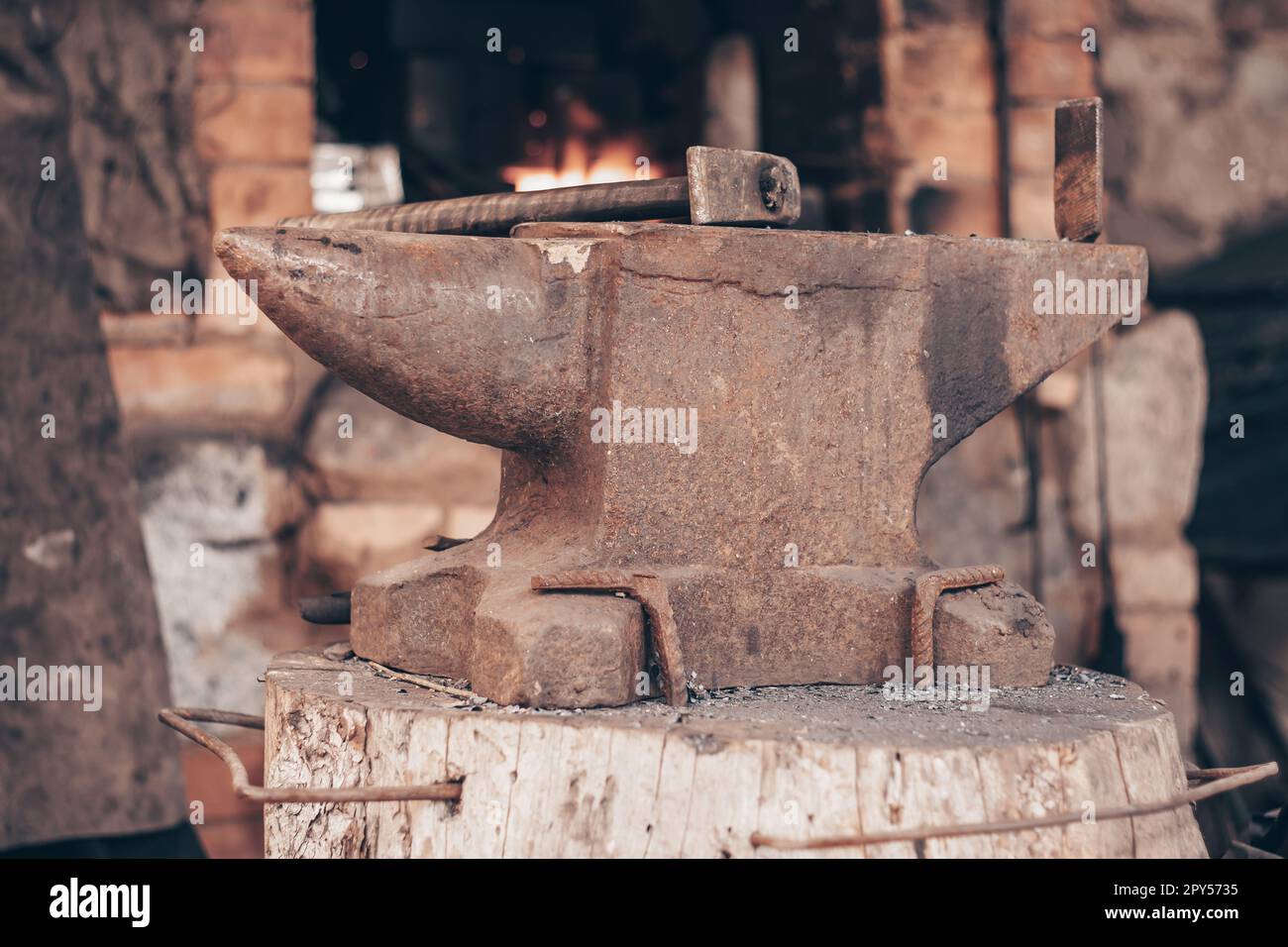 Process metal with hammer on anvil in forge. Strike iron outdoors in ...