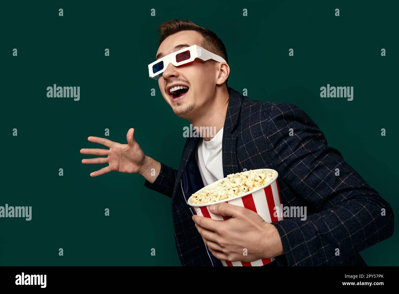 guy in 3d glasses eating popcorn on pink background Stock Photo - Alamy