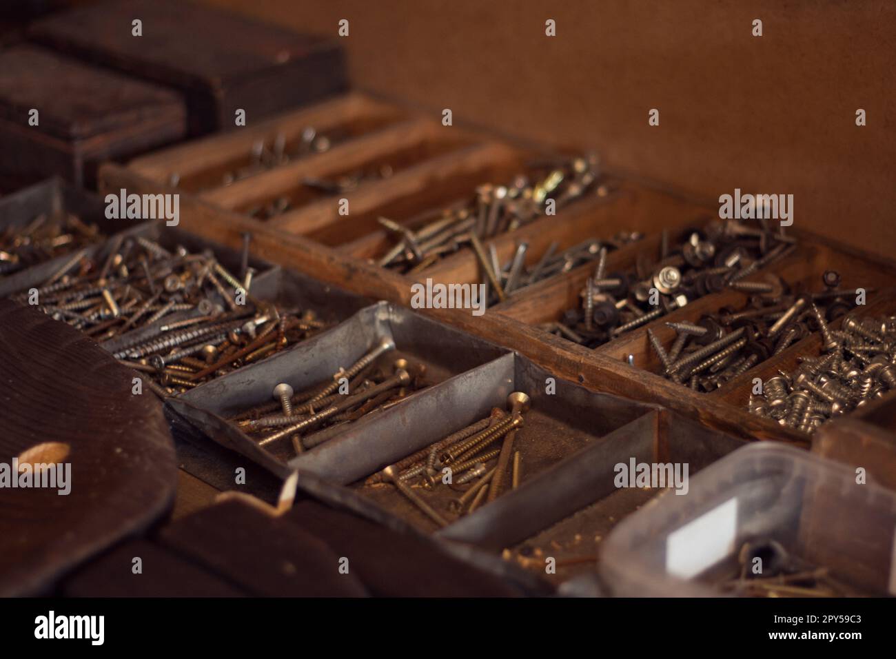 Old wooden toolbox with iron nails, screws, bolts and nuts. Storage of ...