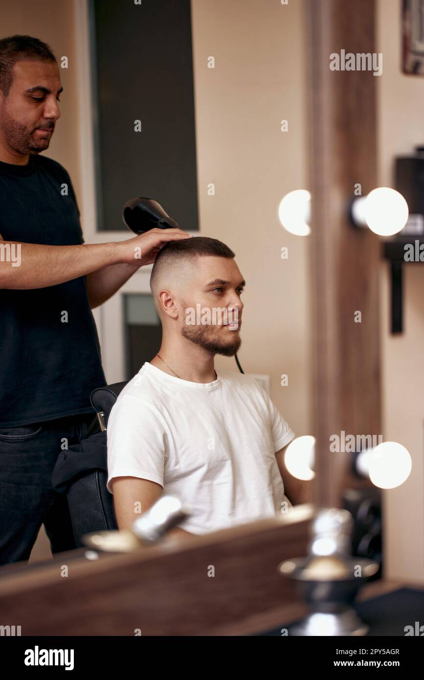 Hairdresser during work with client in barber shop Stock Photo - Alamy