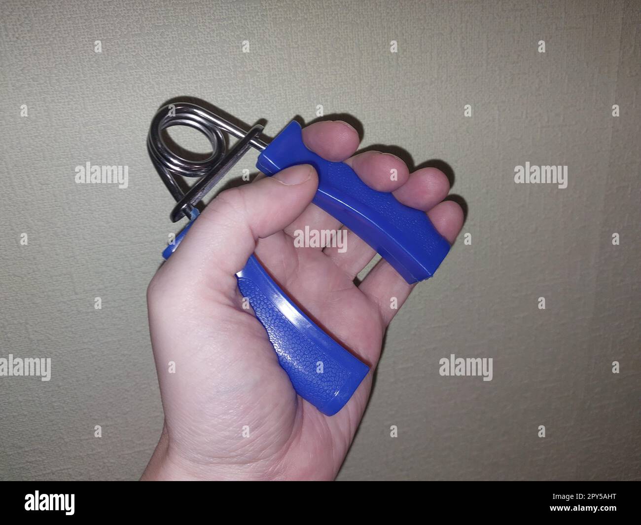A man squeezes a hand expander Stock Photo - Alamy