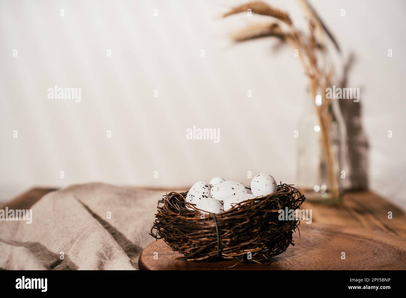 Easter composition of quail spot eggs in nest on wooden table and ...