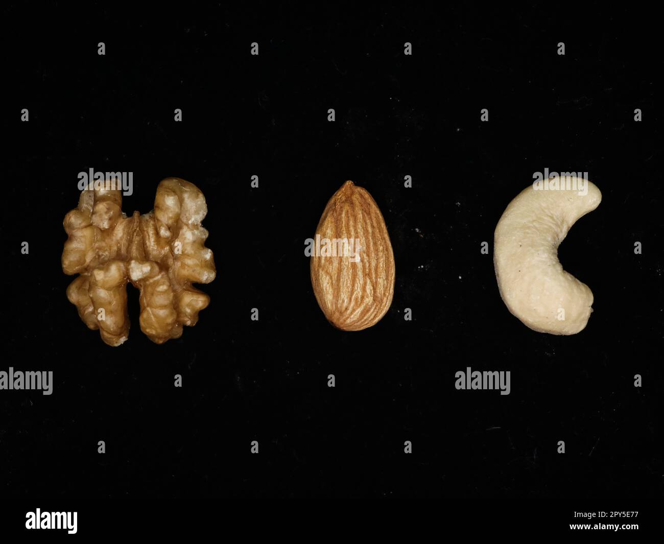 a walnut, almond and cashew nut kept isolated in a black background ...