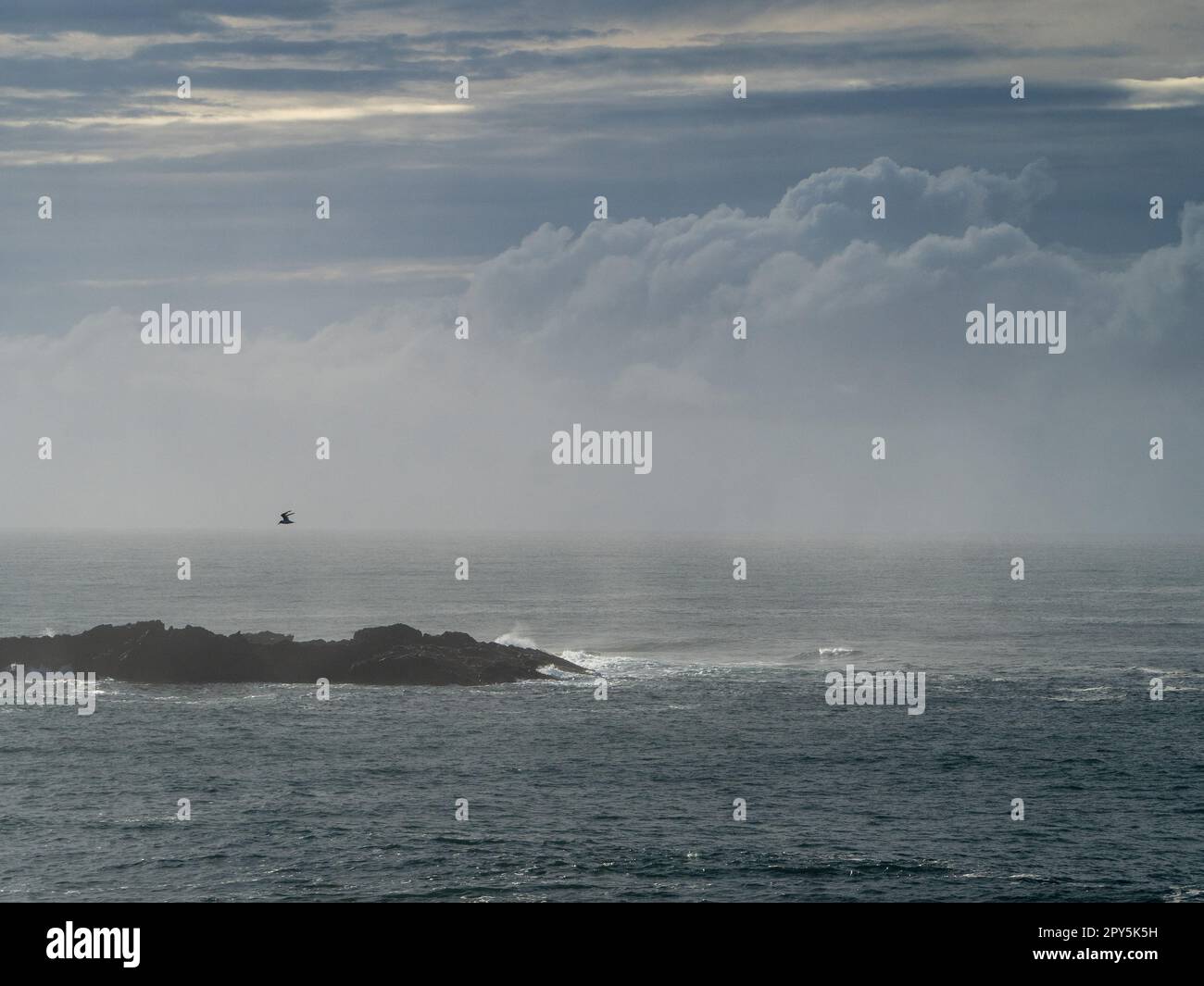 Hazy misty looking ocean scene with majestic clouds, island and sea ...