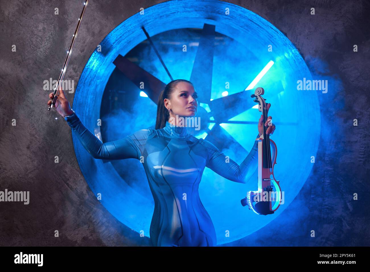 Artistic woman performer playing violin in atmospheric studio Stock ...