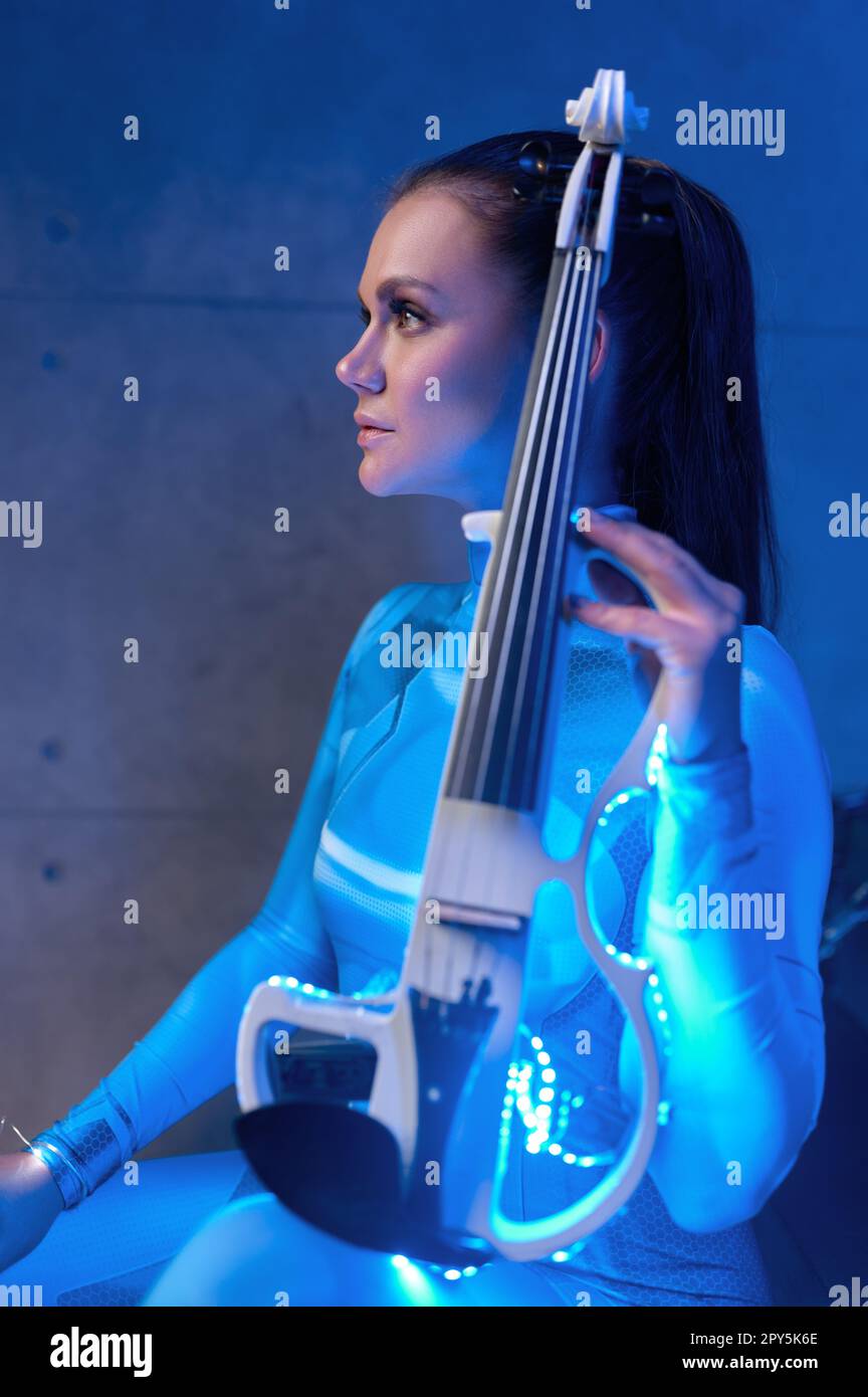 Side view of young woman violinist with electric fiddle Stock Photo - Alamy