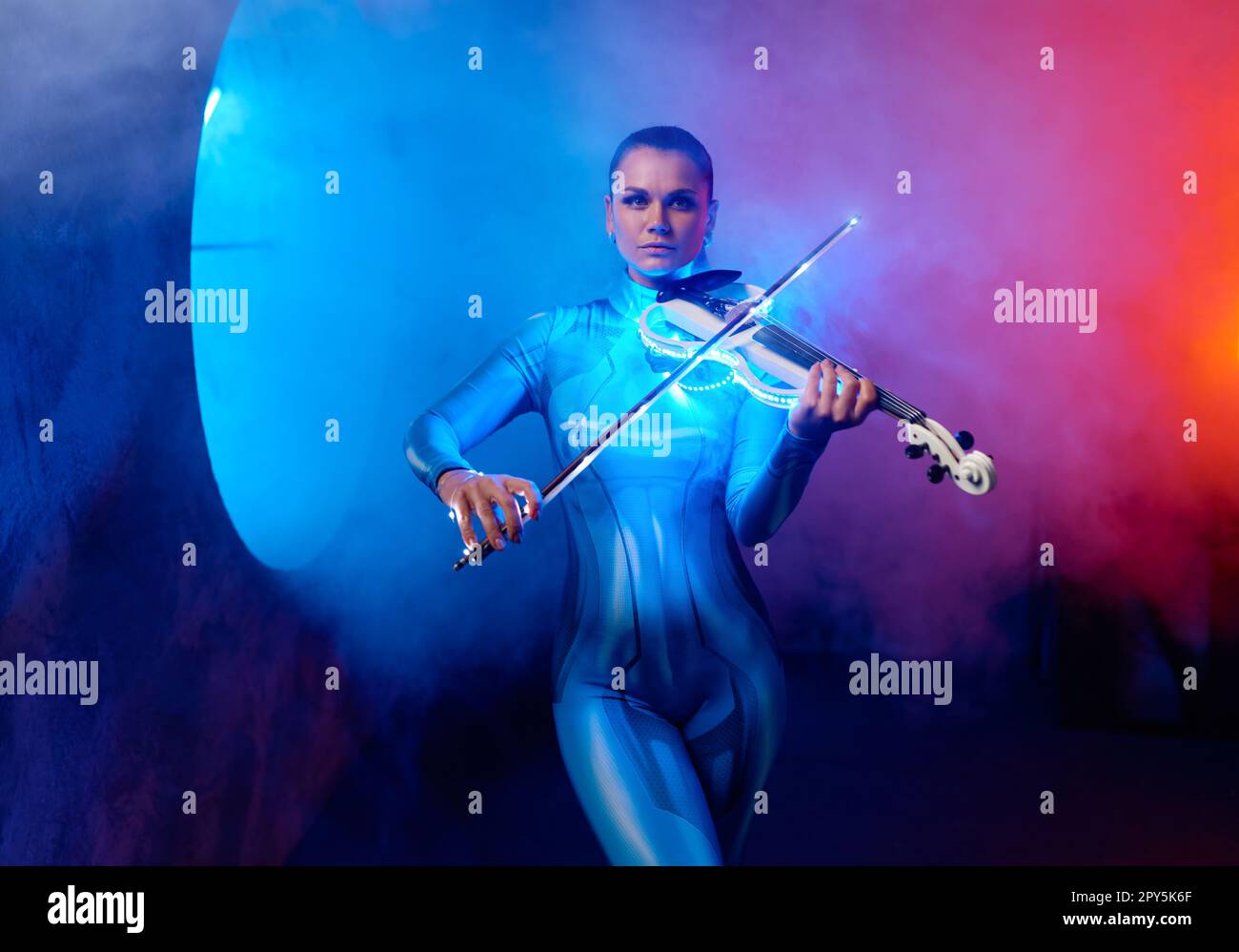 Beautiful violinist playing classic music in neon light Stock Photo - Alamy