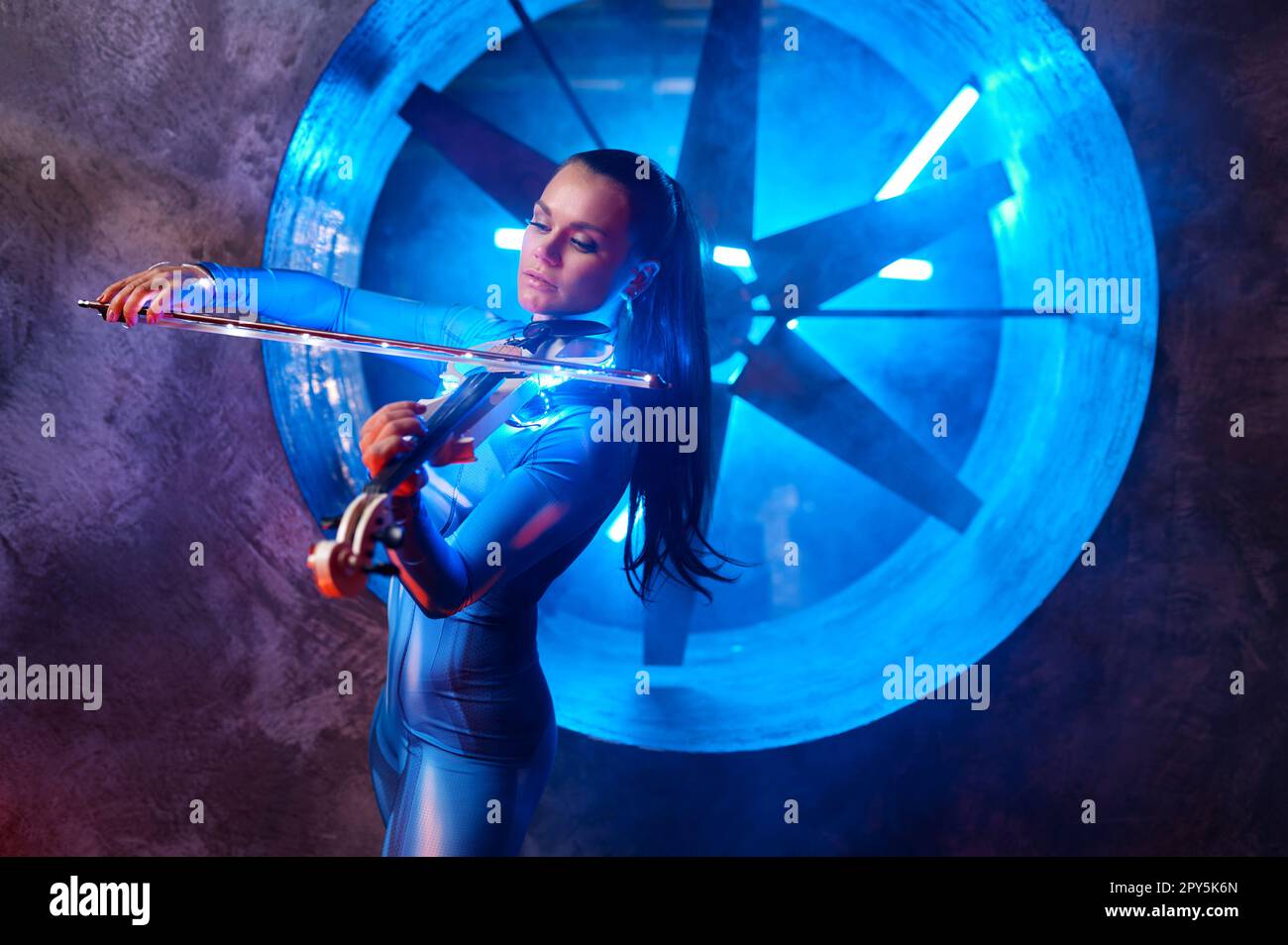 Artistic woman performer playing violin in atmospheric studio Stock ...