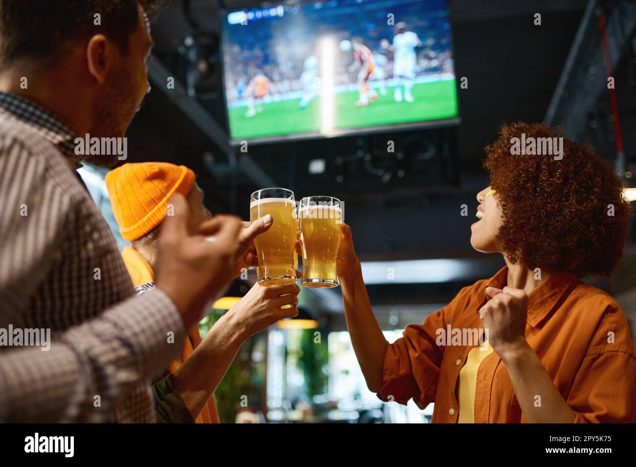 Happy friends drinking beer and cheering together in sports bar Stock ...
