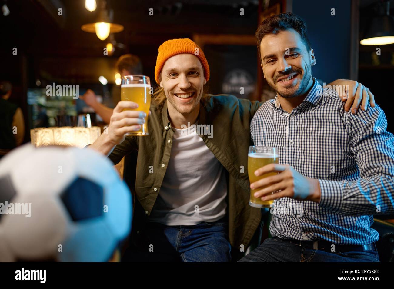 Portrait of friends football fans embracing and looking at camera Stock ...