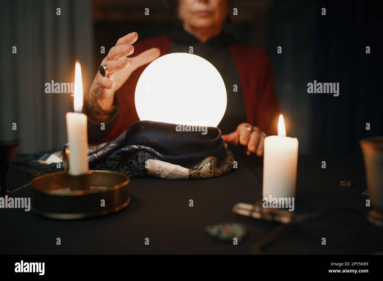 Confident fortune teller doing predictions with illuminated crystal ...