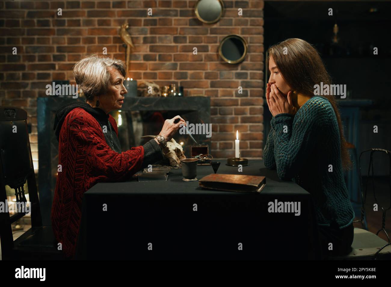 Gypsy witch reading tarot cards for young woman visitor Stock Photo - Alamy