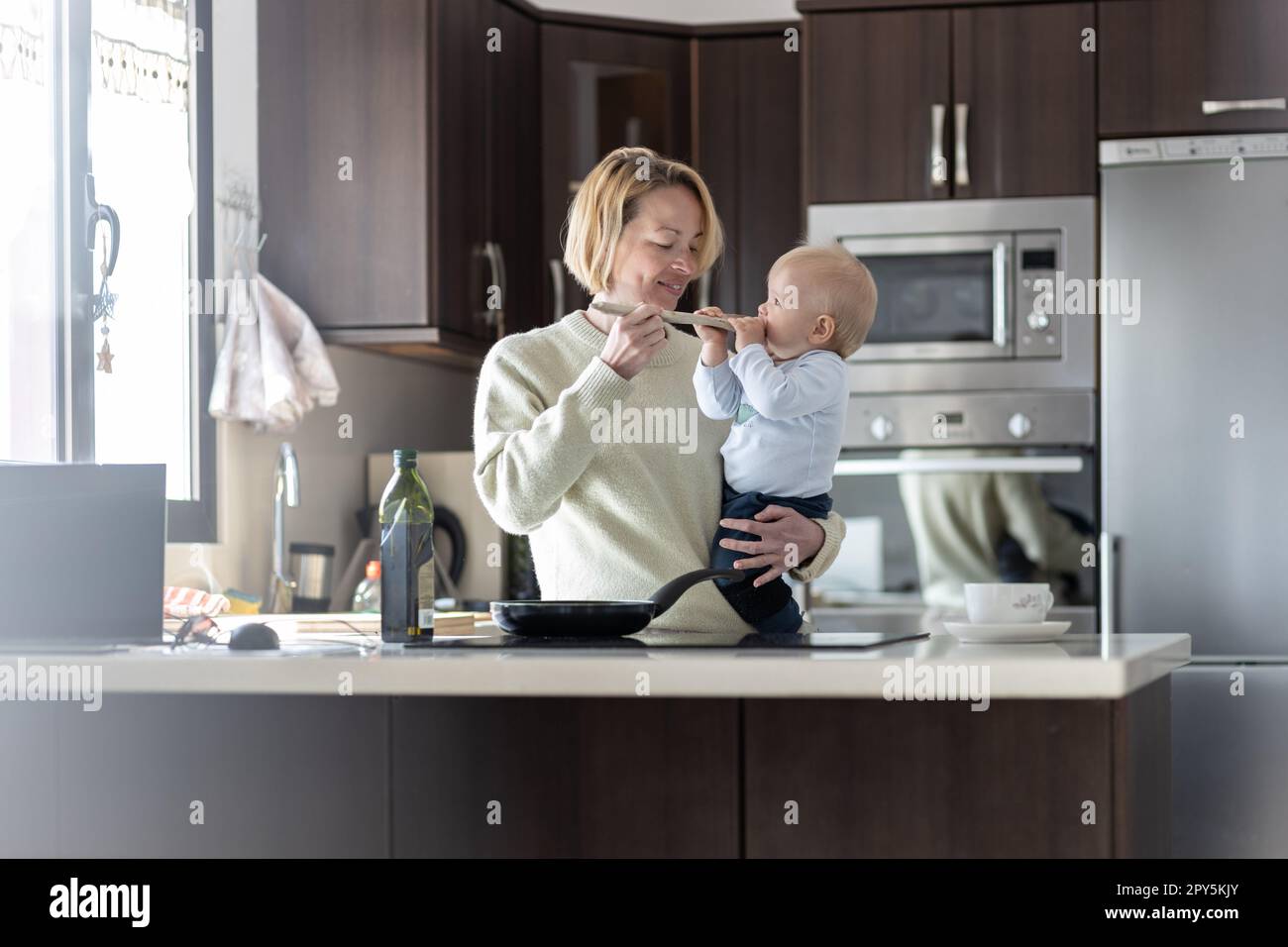 Happy mother and little infant baby boy cooking and tasting healthy ...