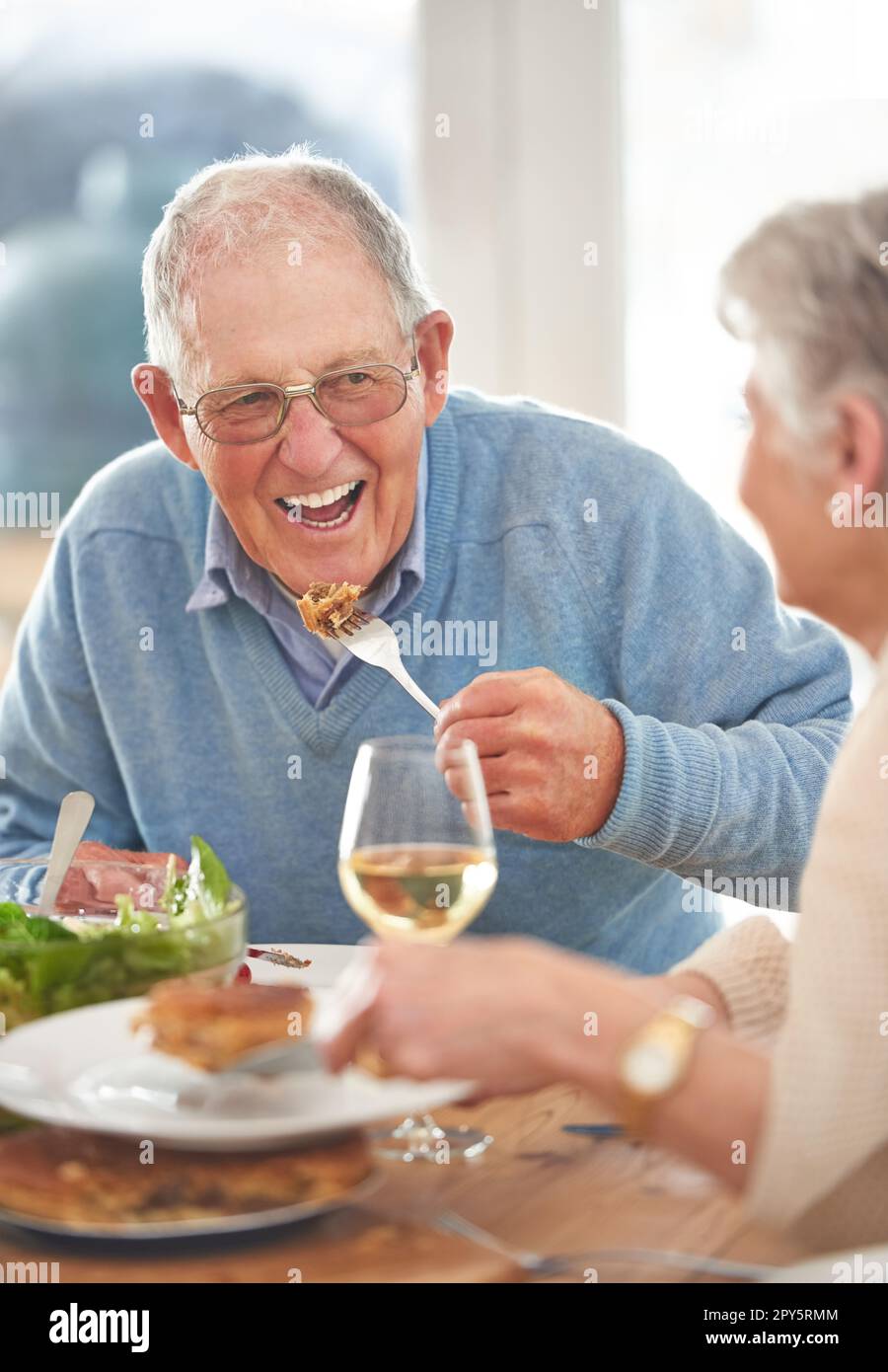 Happy, love and elderly couple eating lunch together in the dining room ...