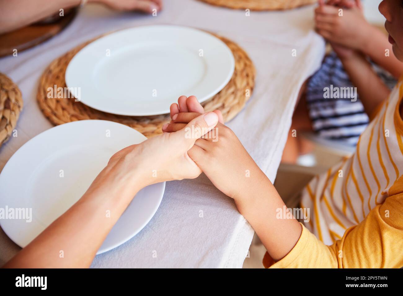 Thank God for food and family. a family holding hands in prayer before ...