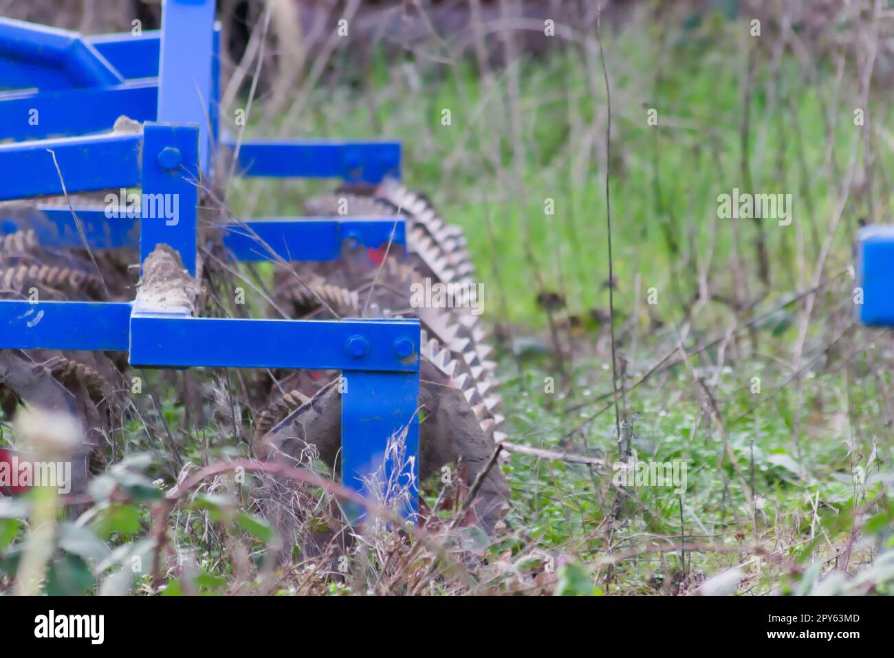 Blue heavy agricultural equipment like plow with sharp steel discs for ...