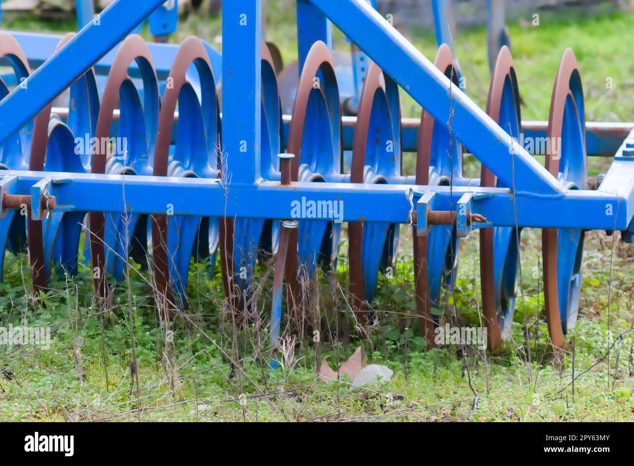 Blue heavy agricultural equipment like plow with sharp steel discs for ...