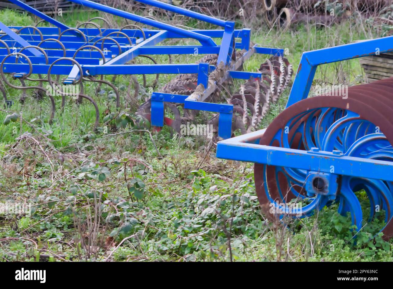 Blue heavy agricultural equipment like plow with sharp steel discs for ...