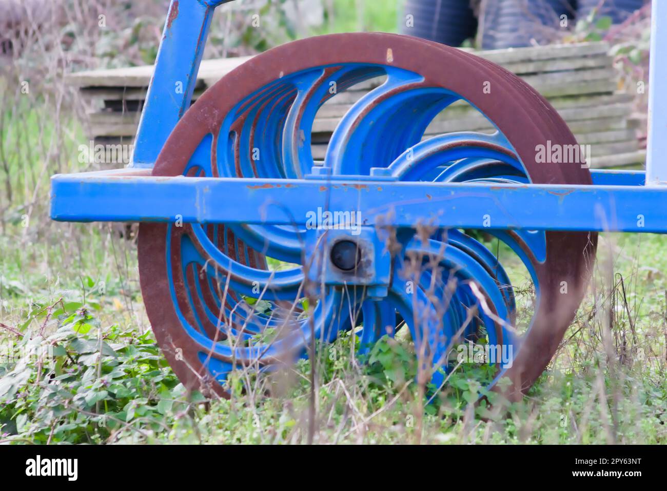 Blue heavy agricultural equipment like plow with sharp steel discs for ...