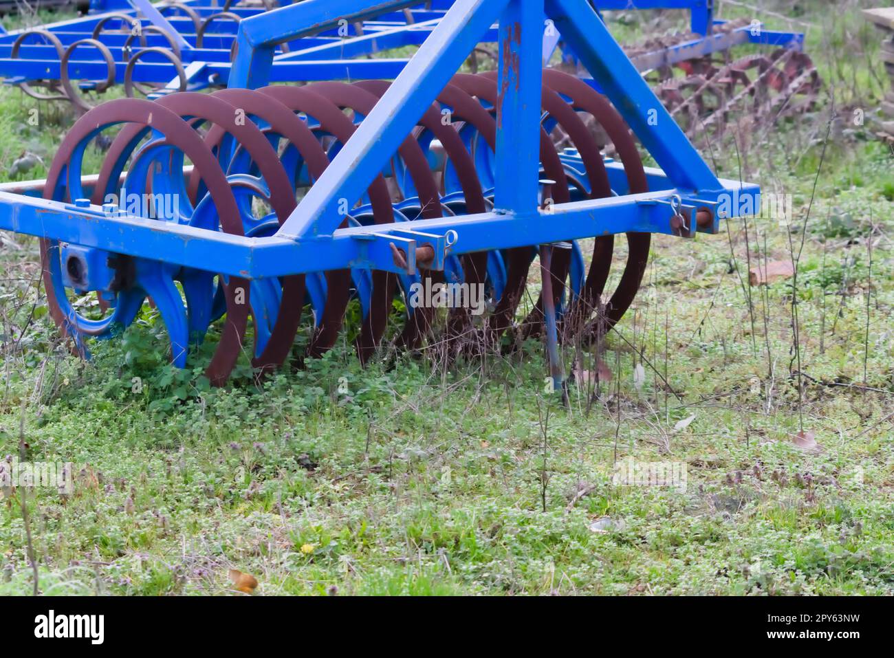Blue heavy agricultural equipment like plow with sharp steel discs for ...