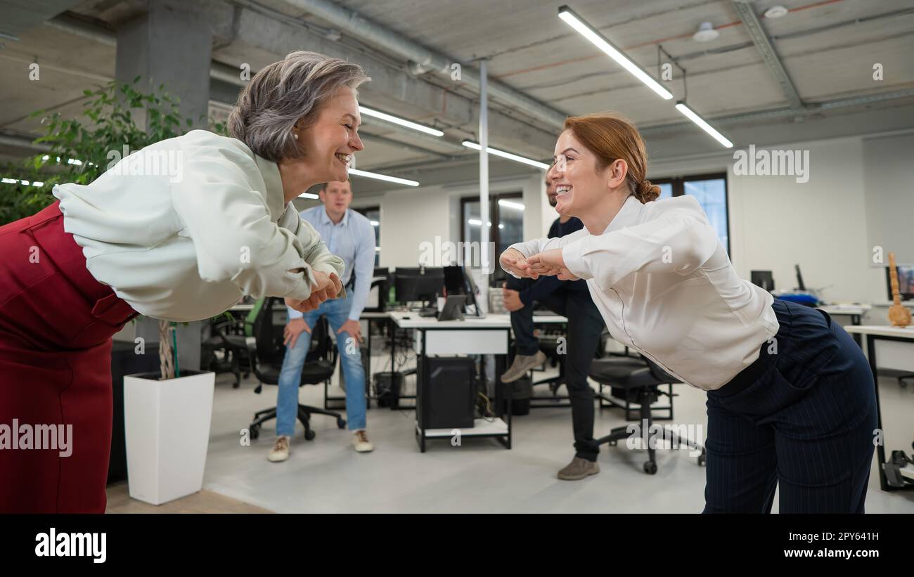 Four office workers warm up during a break. Employees do fitness ...
