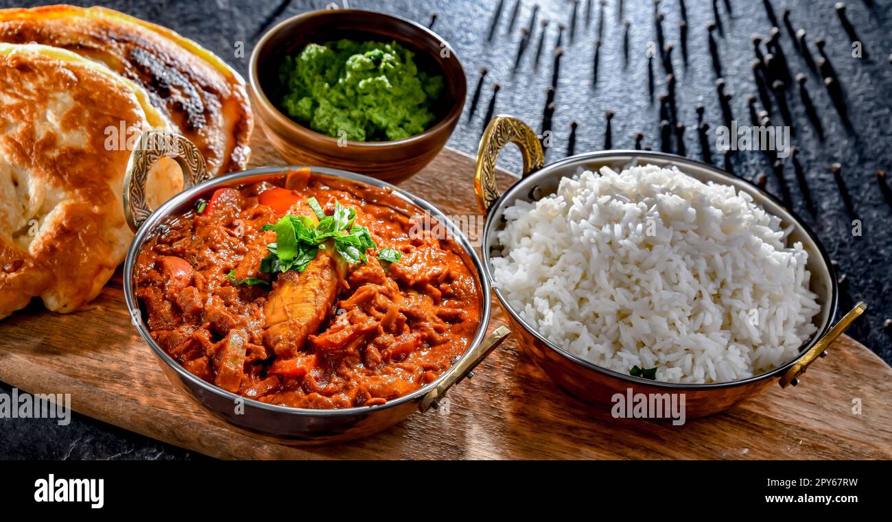 Butter chicken with rice and naan bread served in karahi pots Stock ...