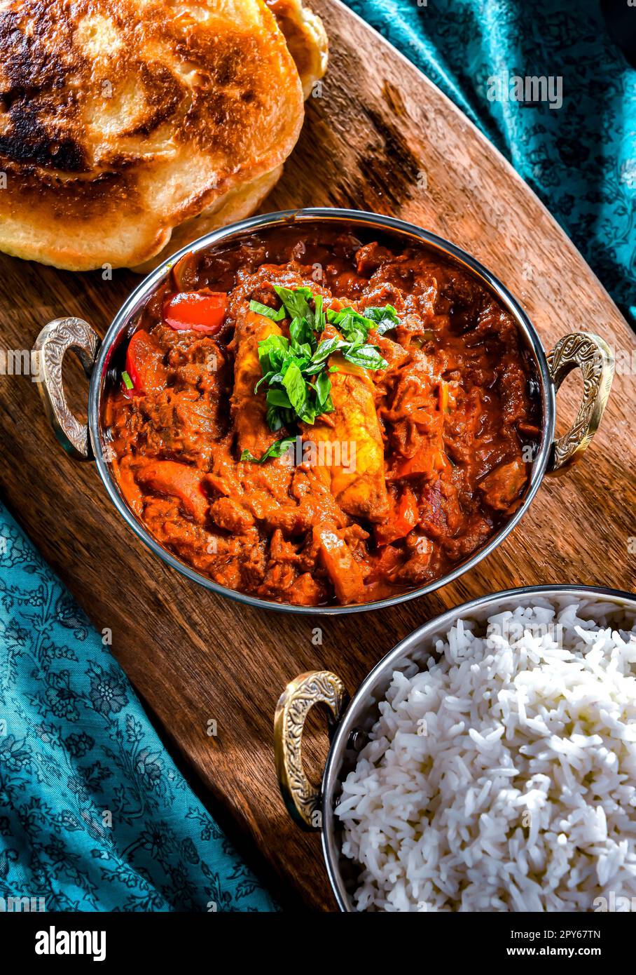 Butter chicken with rice and naan bread served in karahi pots Stock ...