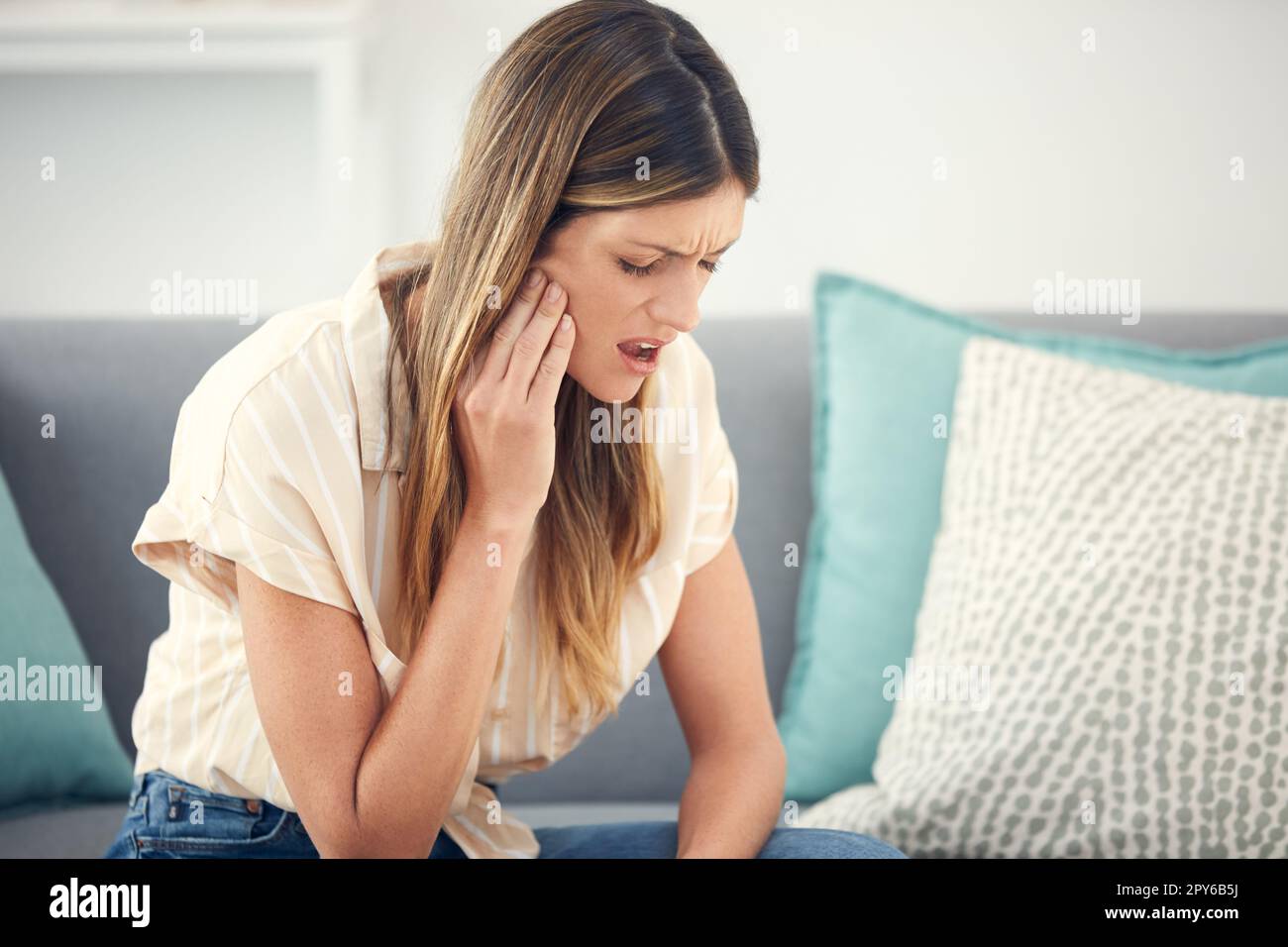 This pain is excruciating. an attractive woman experiencing a toothache ...