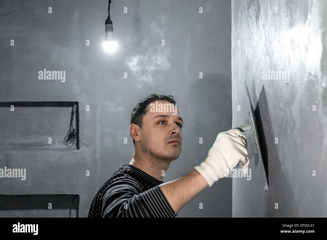 man applies insulation to a bathroom wall Stock Photo - Alamy