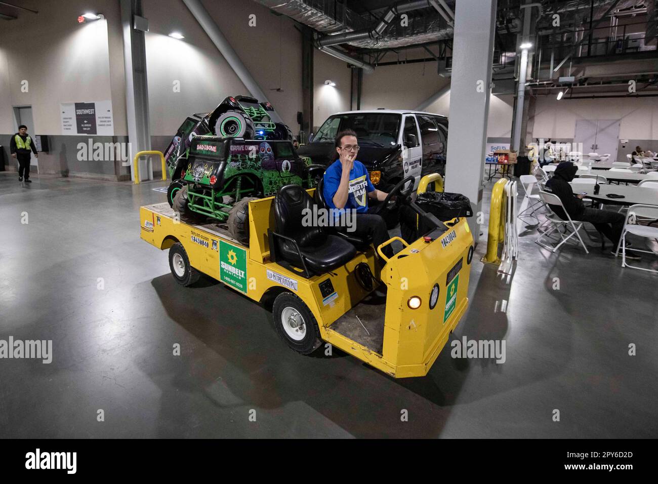 A Monster Jam employee seen hauling mini trucks that fans will race in ...