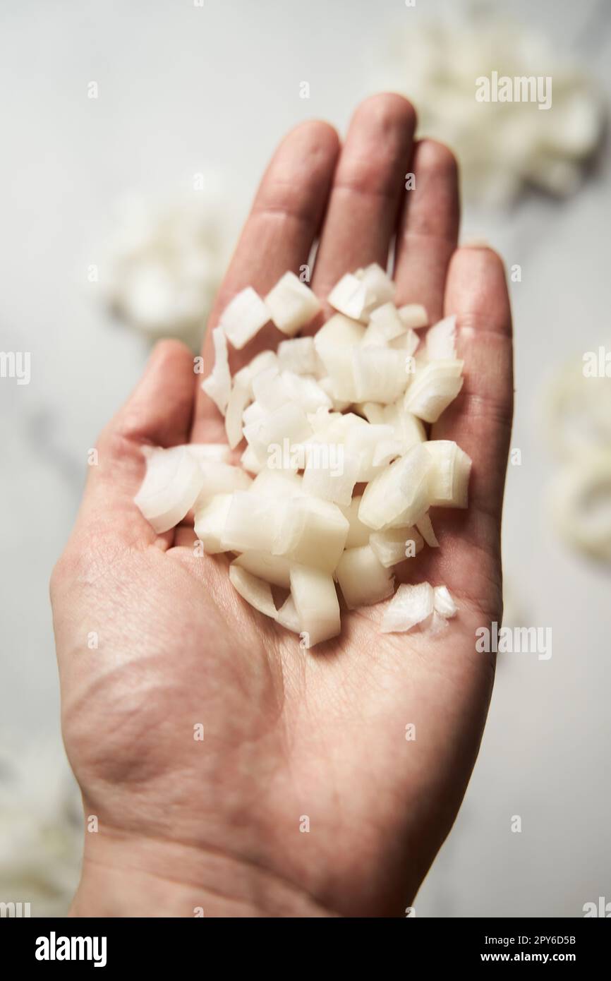 Medium diced onions on mans hand. Photo show how does onion sliced into ...
