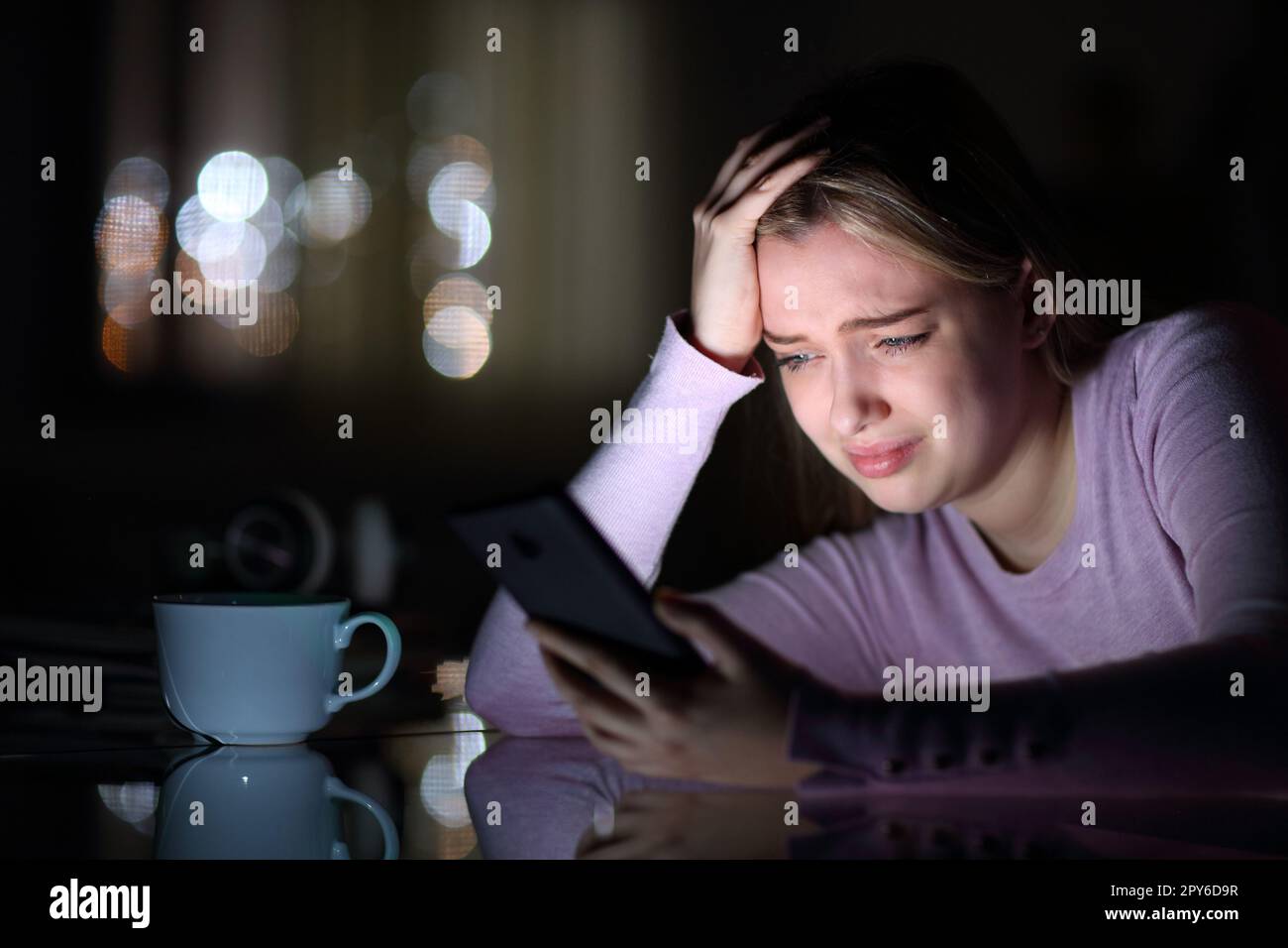 Sad teen crying checking phone in the night Stock Photo - Alamy