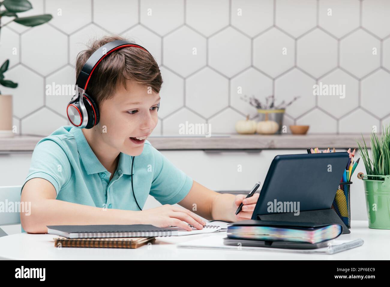 Portrait of young surprised boy looking at screen of tablet, having ...