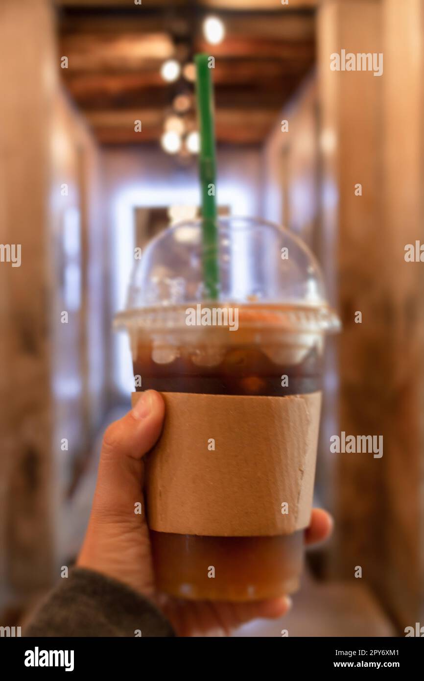 Hand holding iced coffee with orange Stock Photo - Alamy