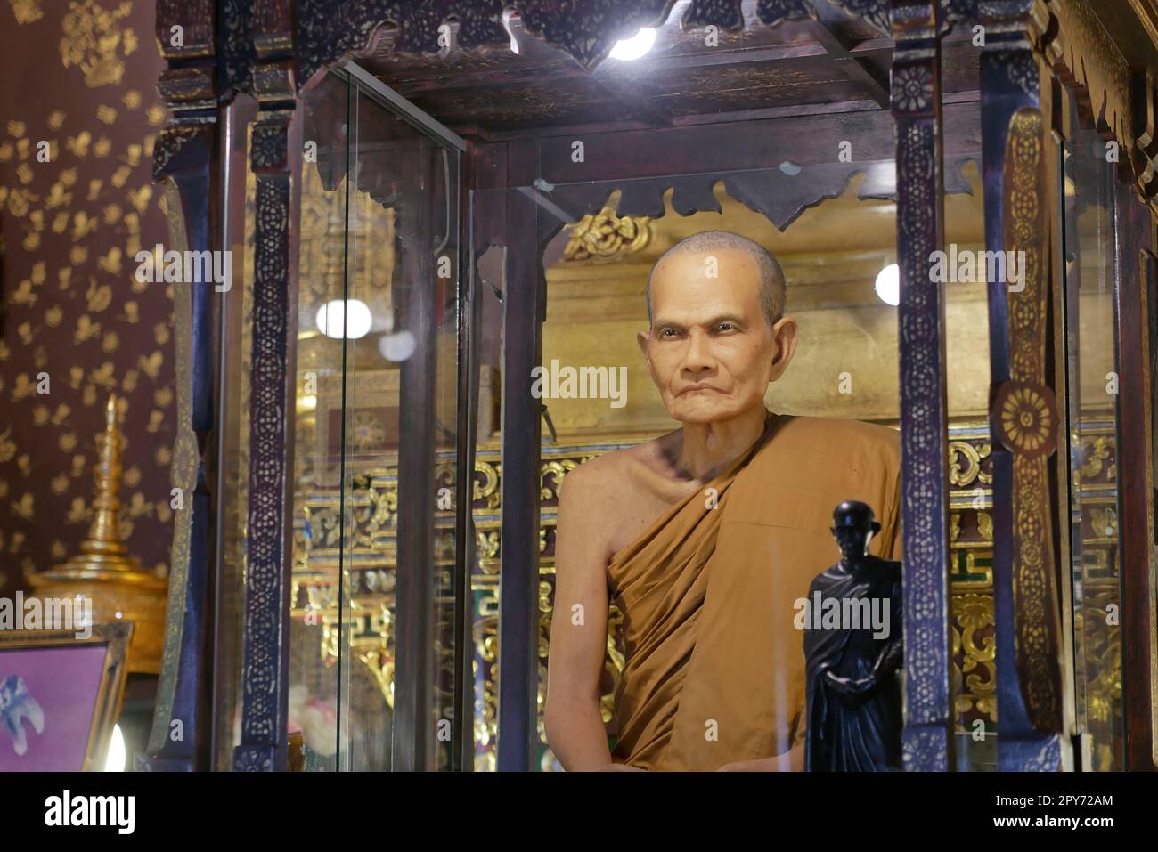 Waxwork Buddhist monk statue seated in meditation in a temple in Chiang ...