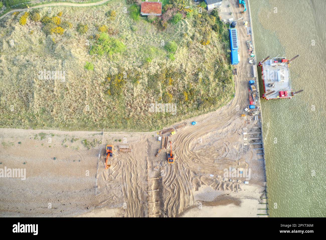 Excavators and working rig repairing the damaged sea wall at the ...