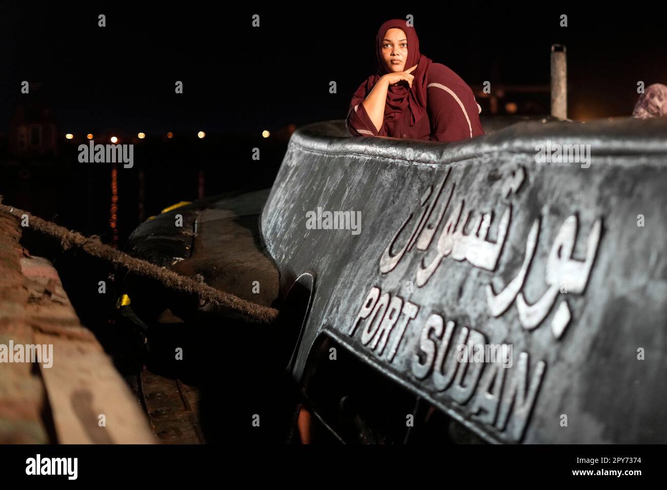 A Sudanese evacuee waits before boarding a Saudi military ship to ...