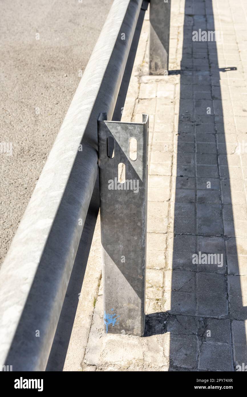 A zinc-coated metal guardrail installed on an urban street Stock Photo ...