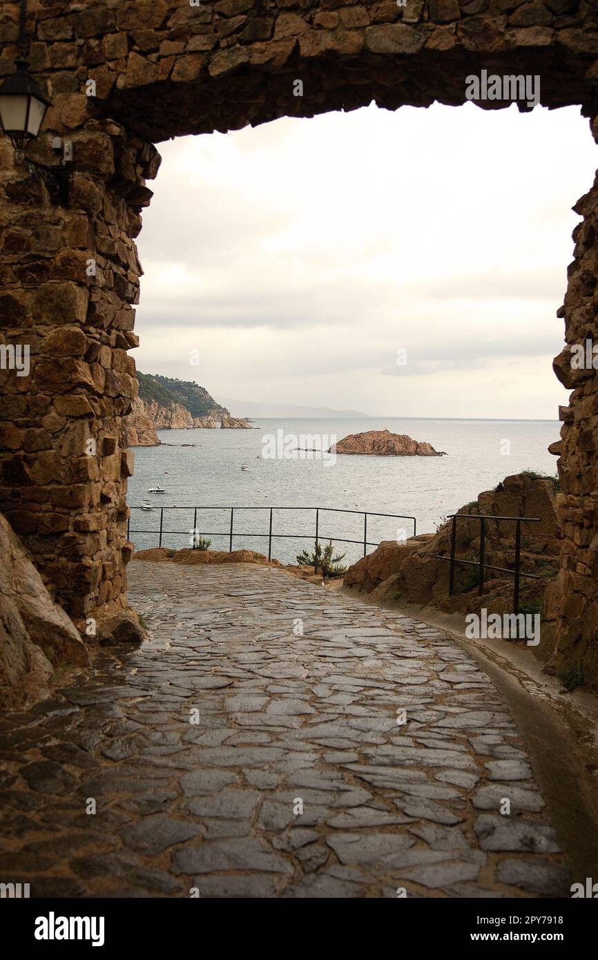 A picturesque stone archway path leading to a stunning view of the ...