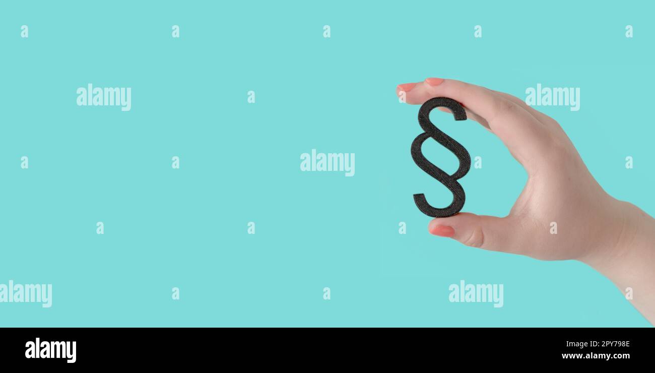 Woman hand hold a paragraph symbol in front of blue background ...