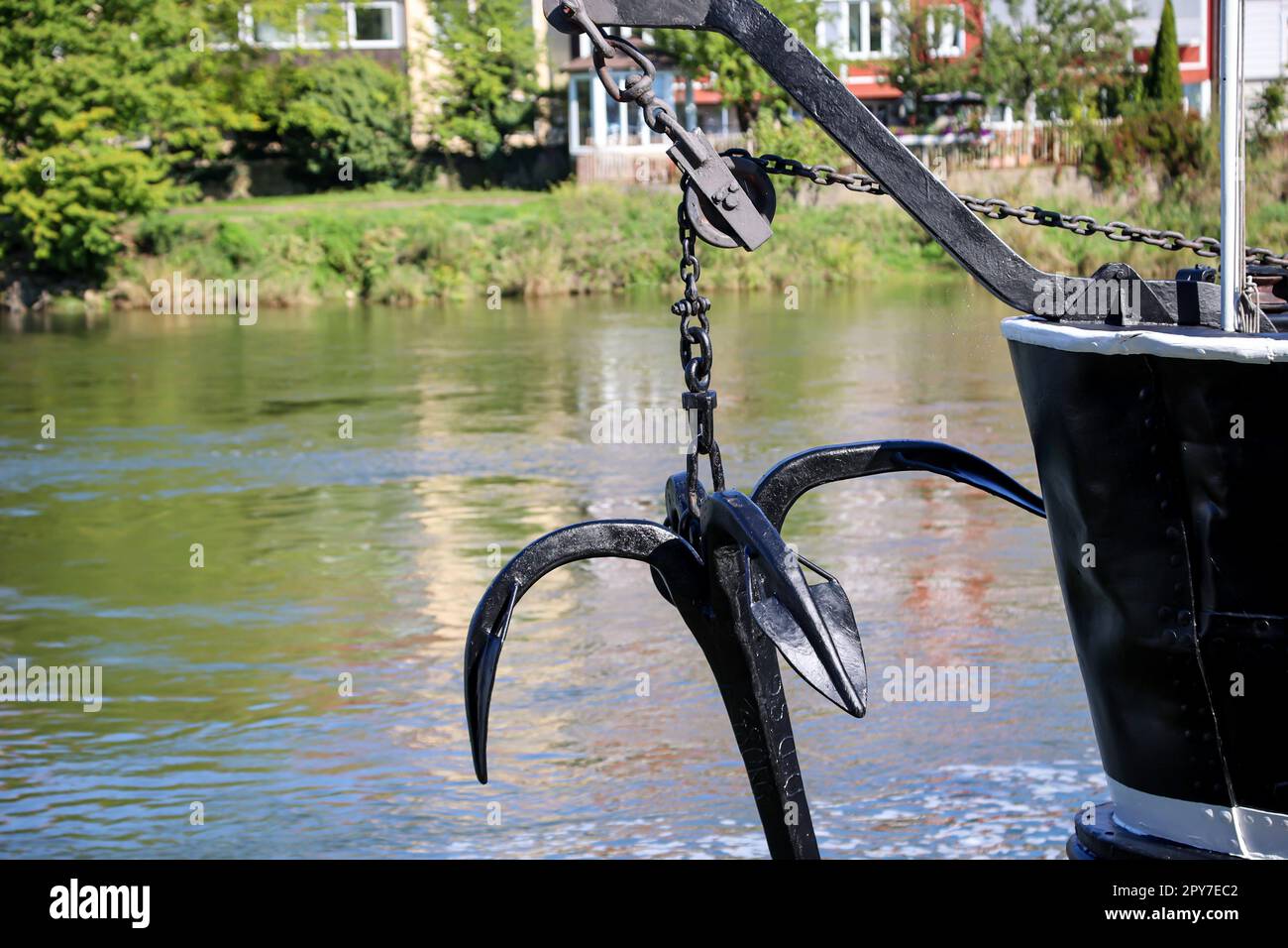 An anchor hangs from a chain on a barge Stock Photo - Alamy