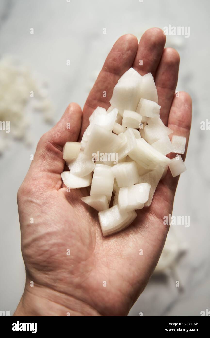 Large diced onions on mans hand. Photo show how does onion sliced into ...