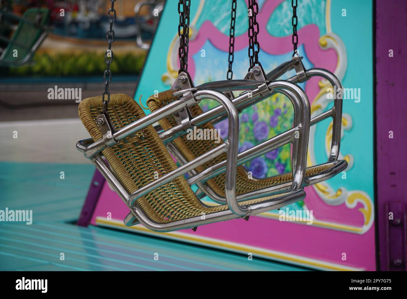 A vibrant playground swing set overlooking an amusement park Stock ...