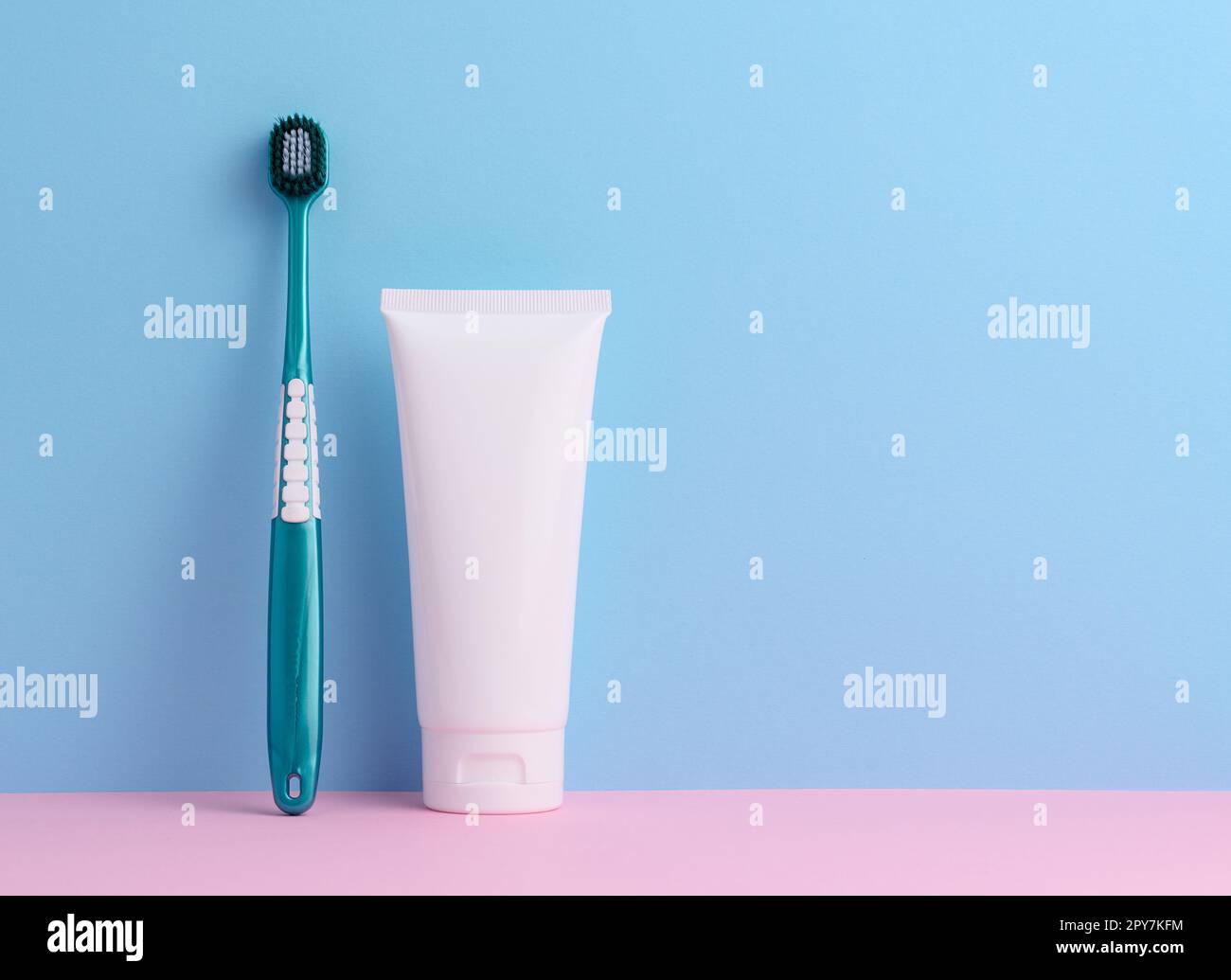 White plastic toothpaste tube and toothbrush on a blue background Stock ...