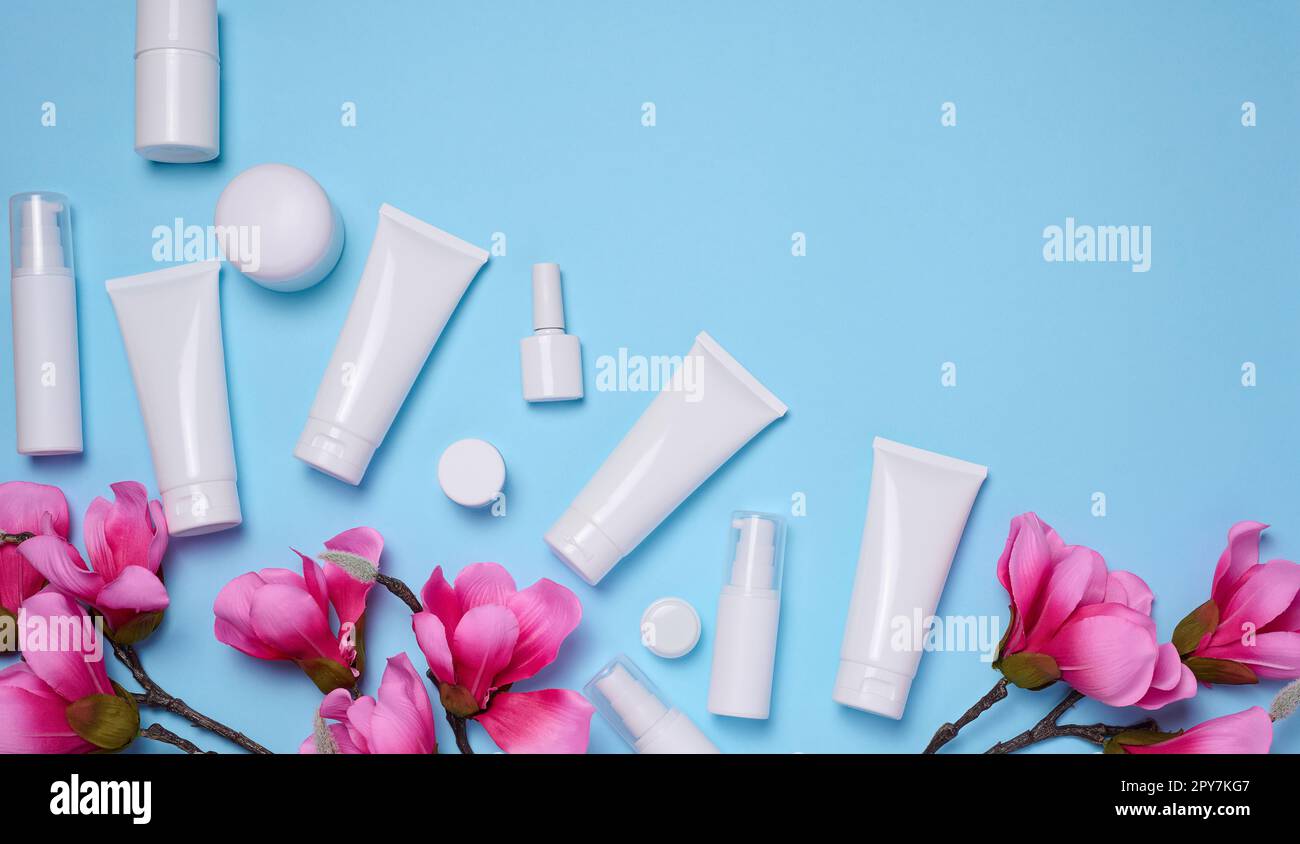 White plastic tubes, jars, and containers for cosmetic products on a ...
